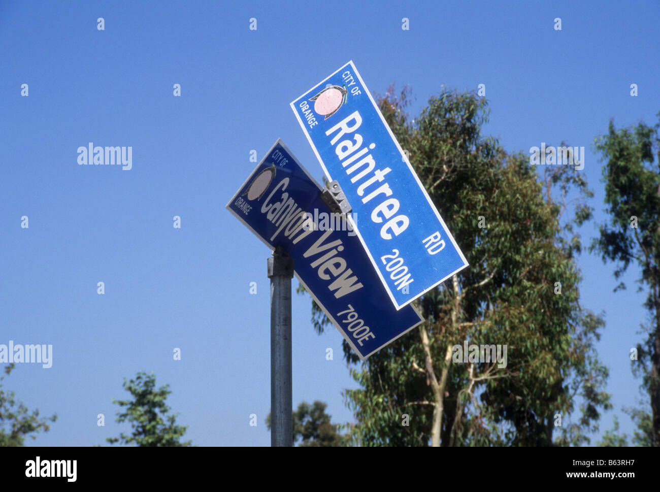 Wind-blown street sign hangs at odd angle from post Stock Photo - Alamy