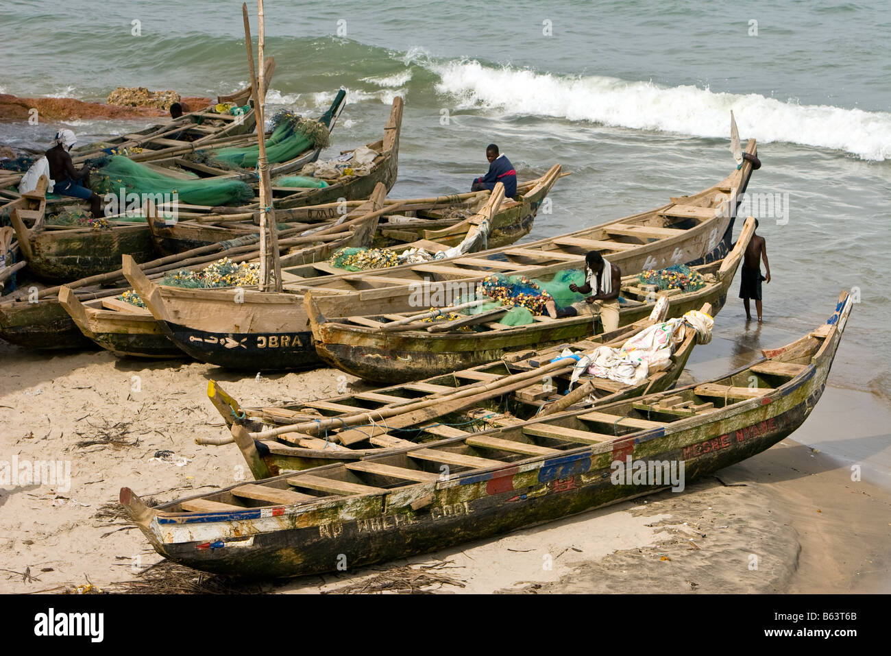 Traditional fishing boats docked on the beach in Cape Coast, Ghana ...