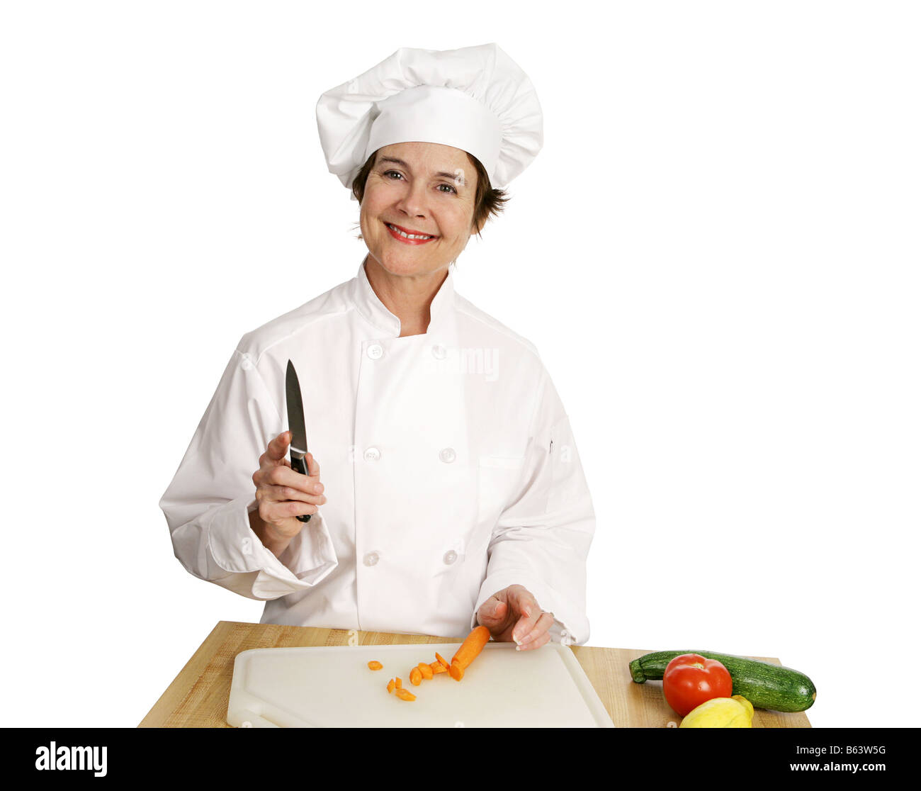 A friendly chef smiling at the camera as she prepares to chop ...