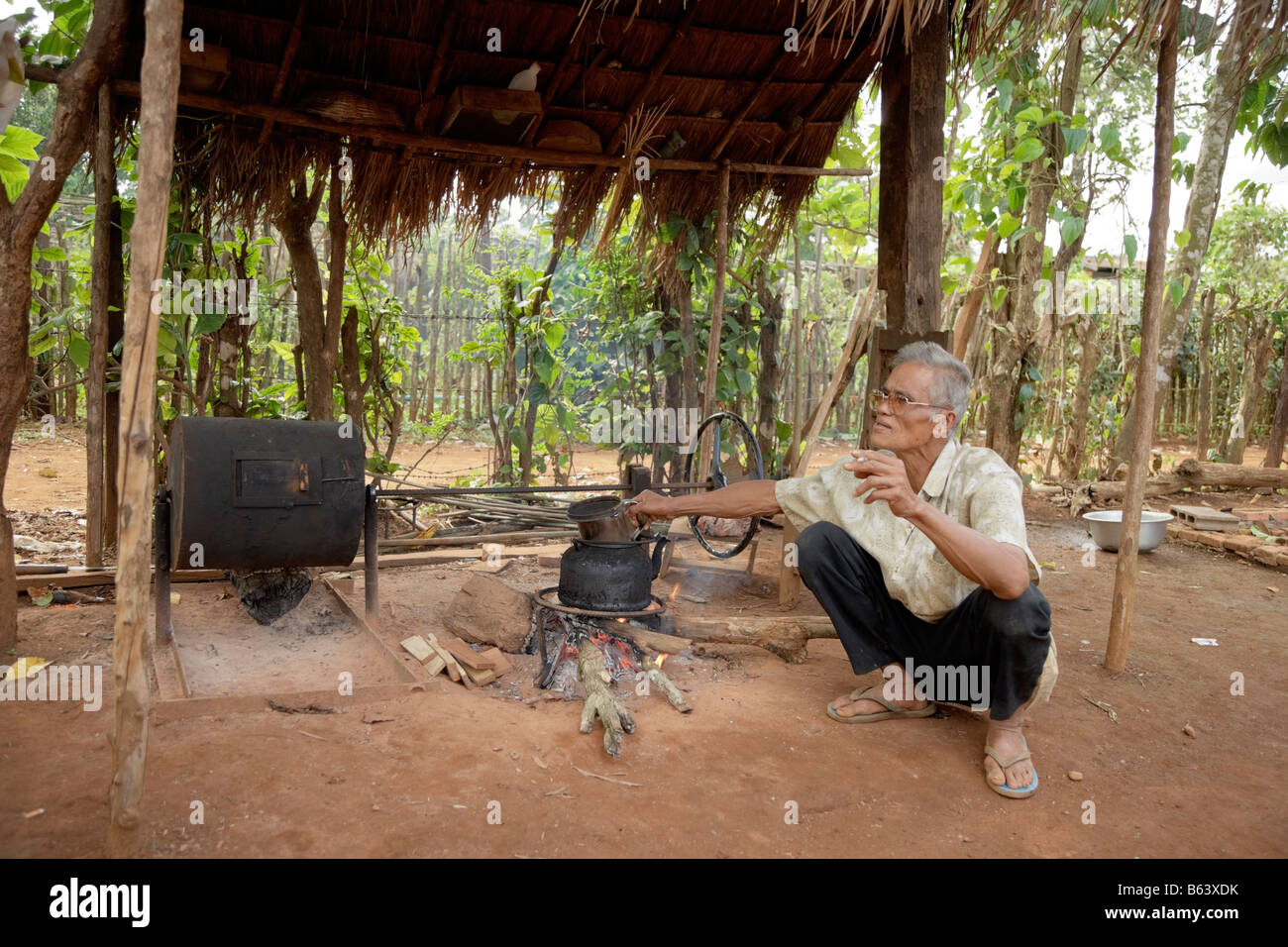 Lao coffee farmer and roaster prepares sample of his coffee, Bolaven ...