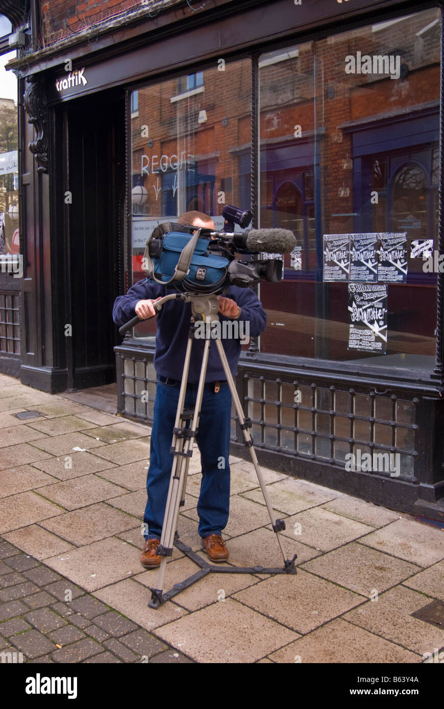 Professional Cameraman with tv camera on tripod waiting for someone to ...