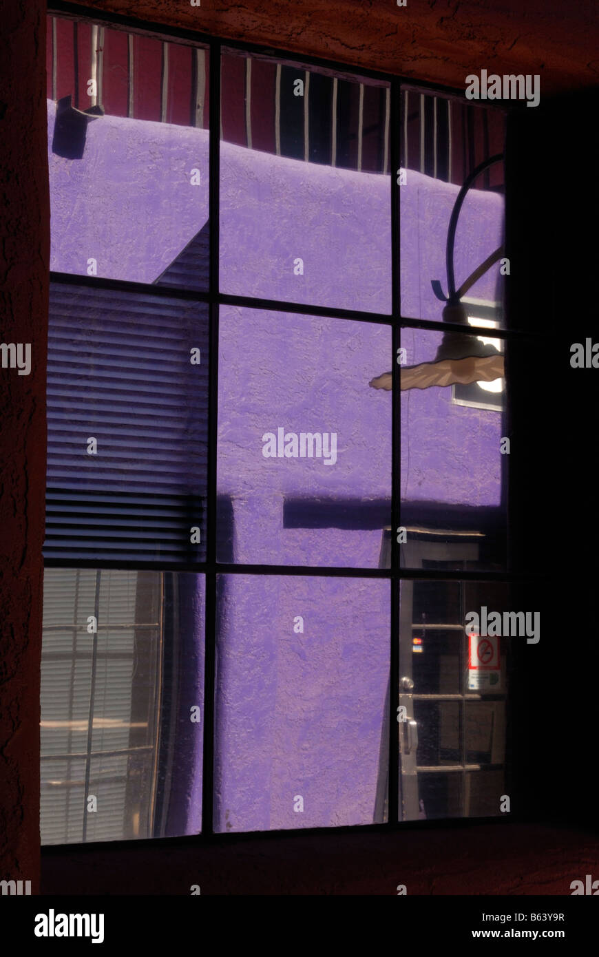 Reflection of door window and purple wall into window on red wall Stock ...