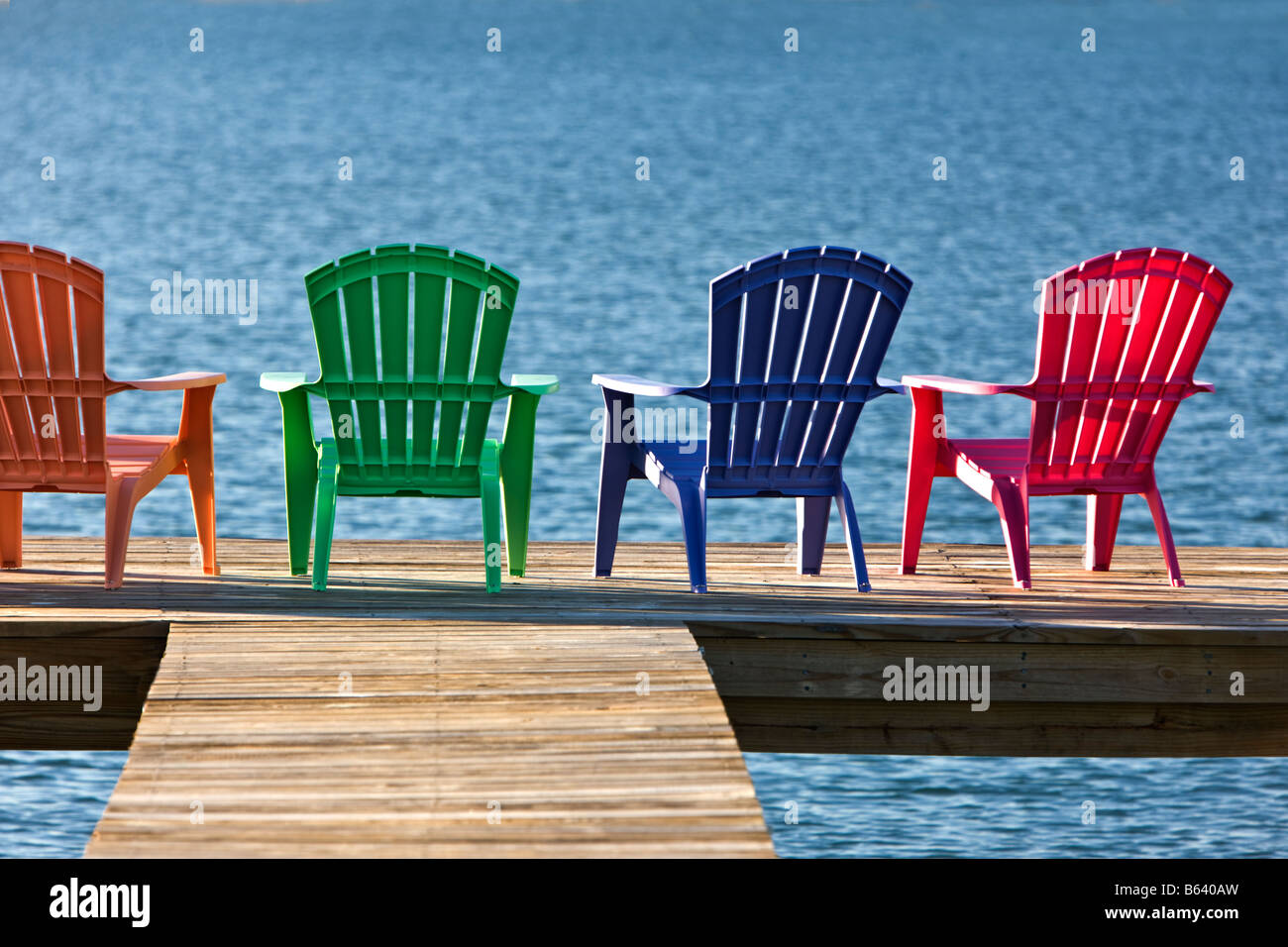Colorful chairs on dock overlooking waterway Stock Photo - Alamy