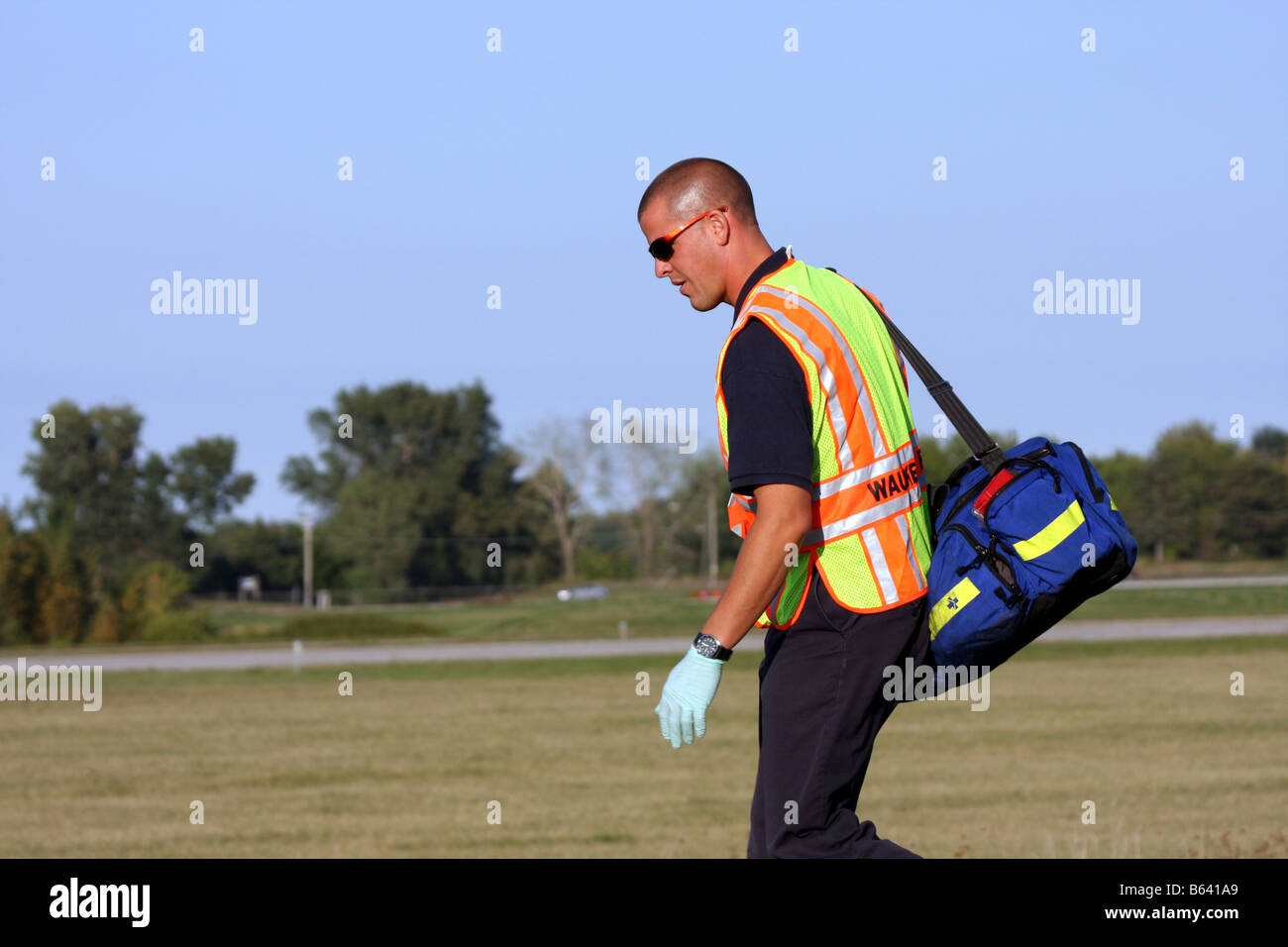 EMS personnel walking with medical gear over to the injured at a mass ...