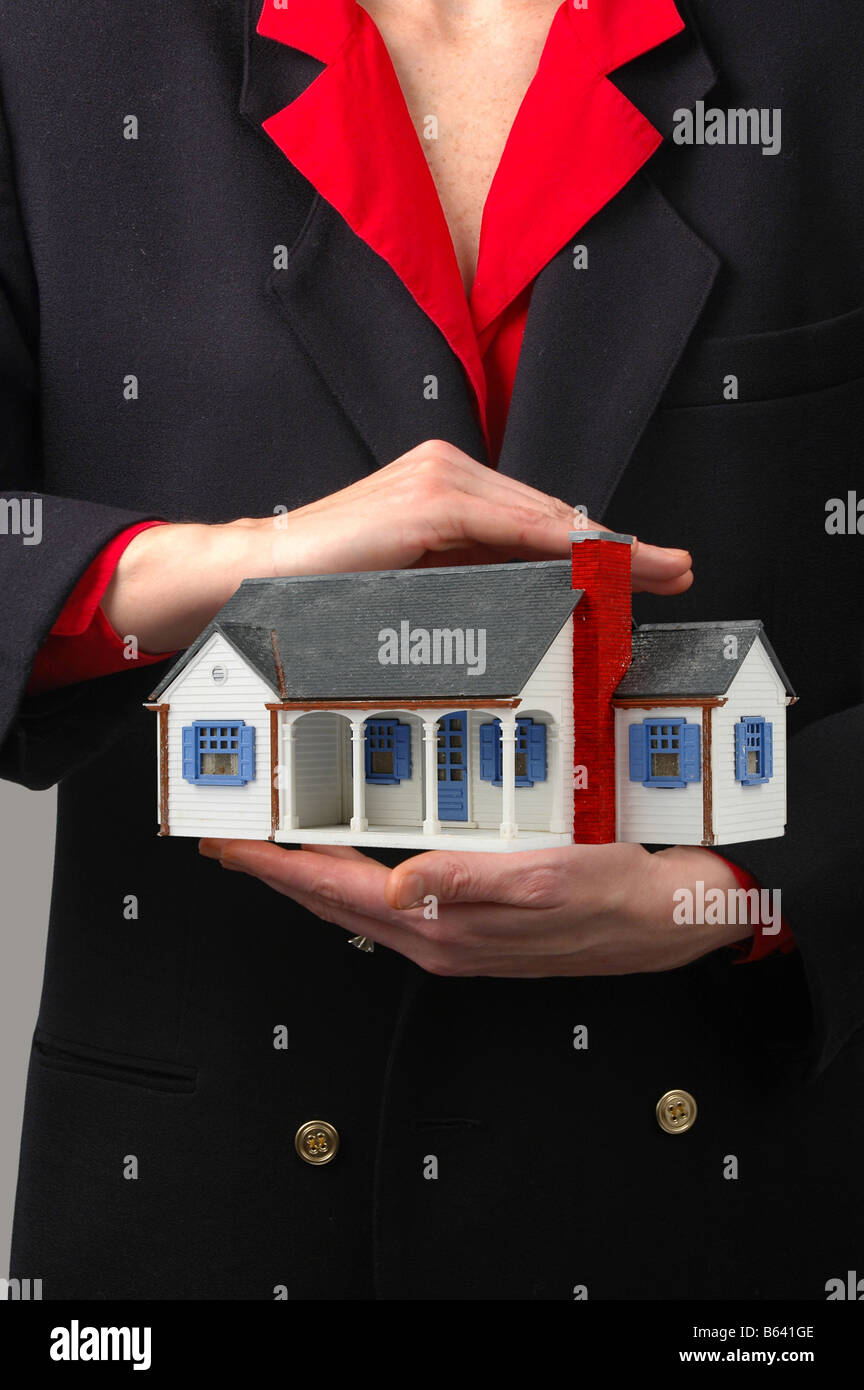 Woman holding house representing home ownership and the Real Estate ...