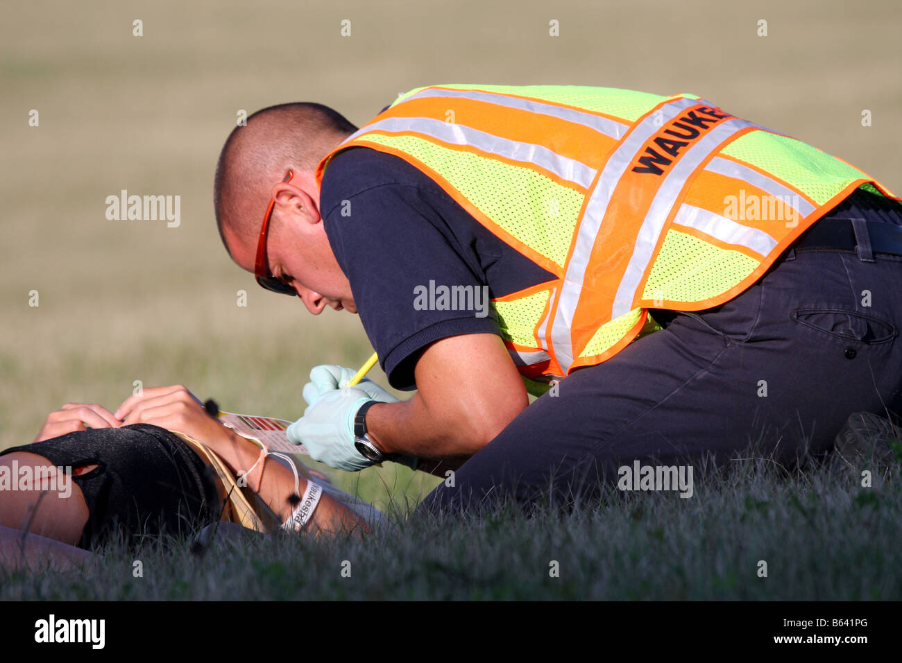 An EMS personnel writing on the triage tag of a women injured at a mass ...