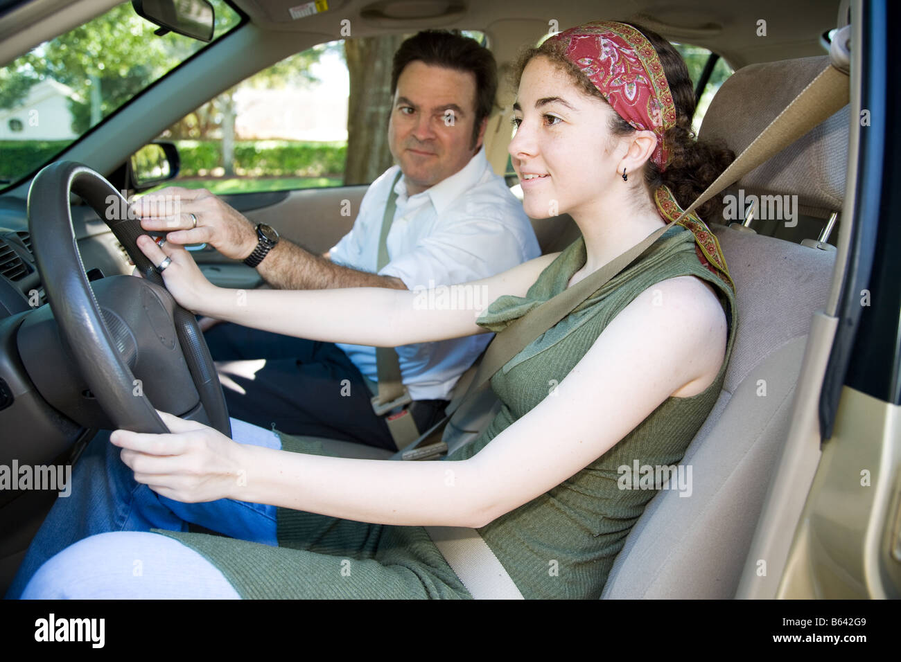 Teen girl taking driving lessons from an instructor or her father Stock ...