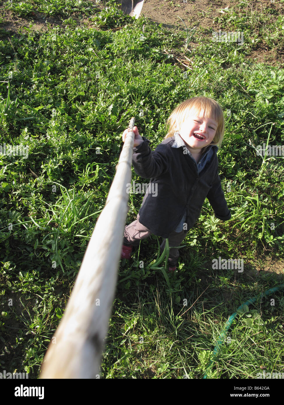 Child girl playing with stick Stock Photo - Alamy