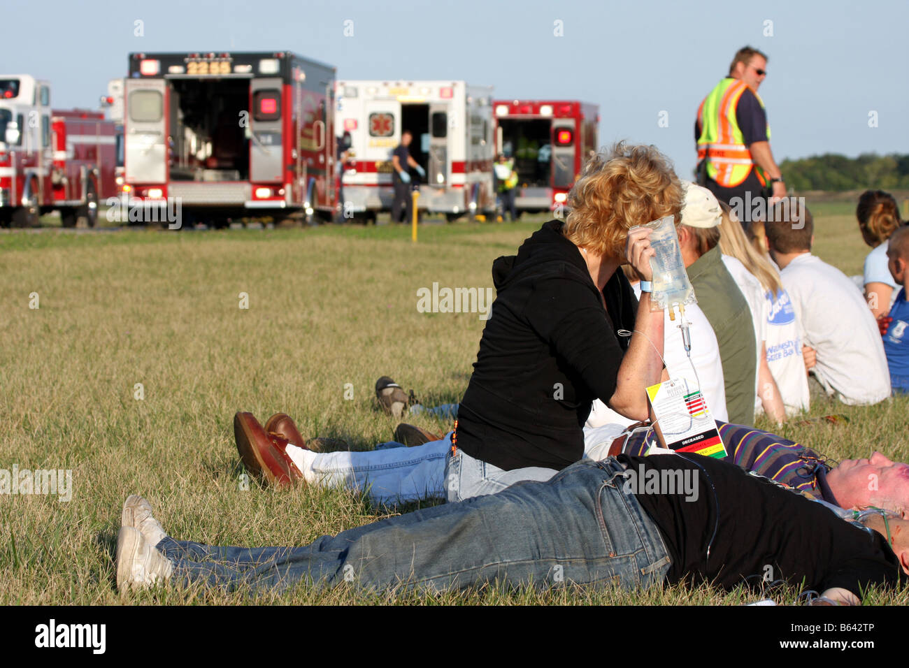 A mass casualty scene where the less injured are sitting in the grass ...