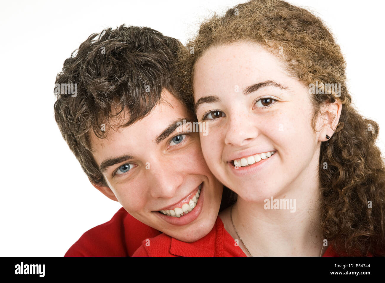 Closeup portrait of cute teen boy and girl with perfect teeth against a ...