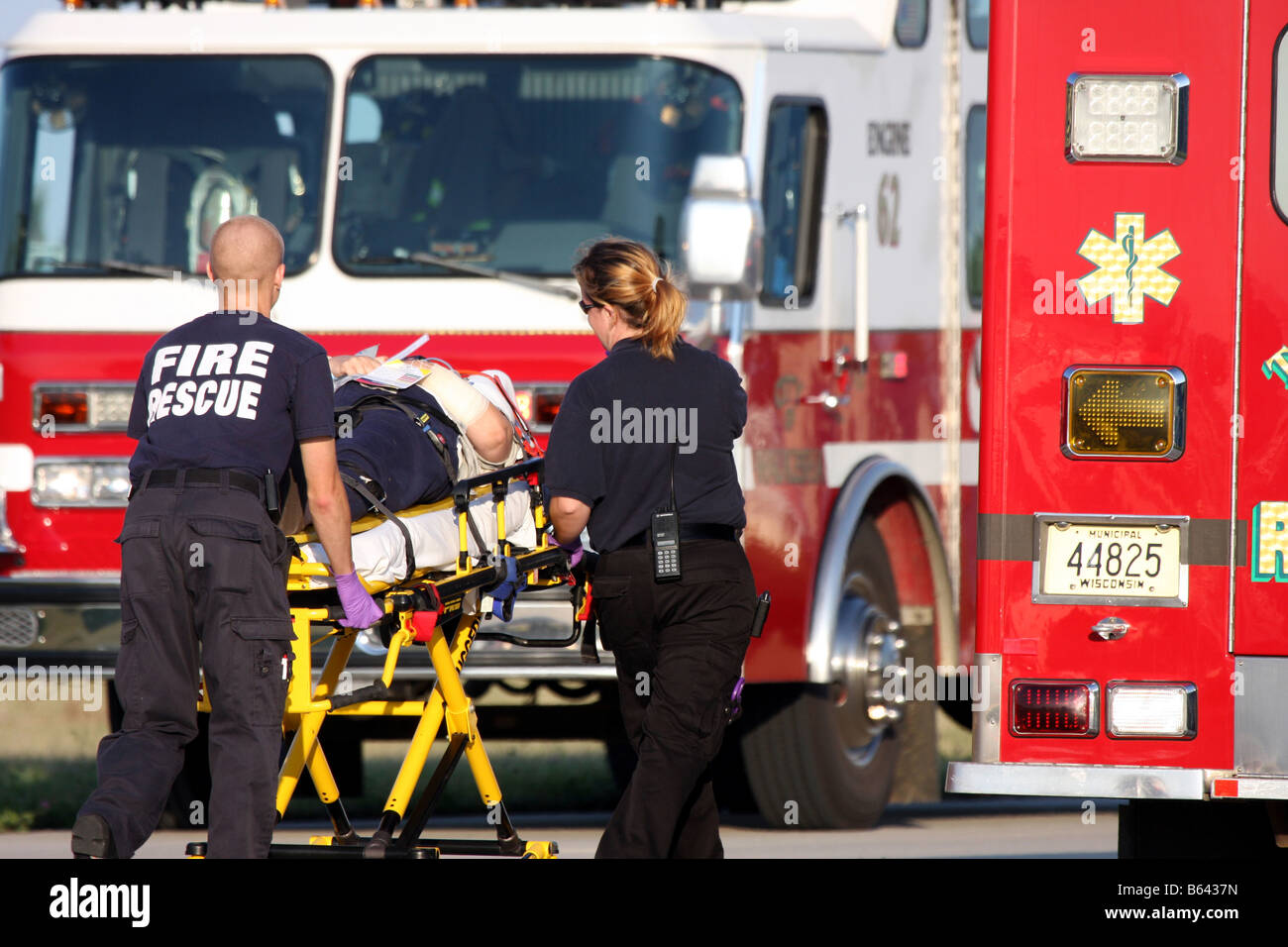 Paramedics rolling a patient on a stretcher to the ambulances on the ...