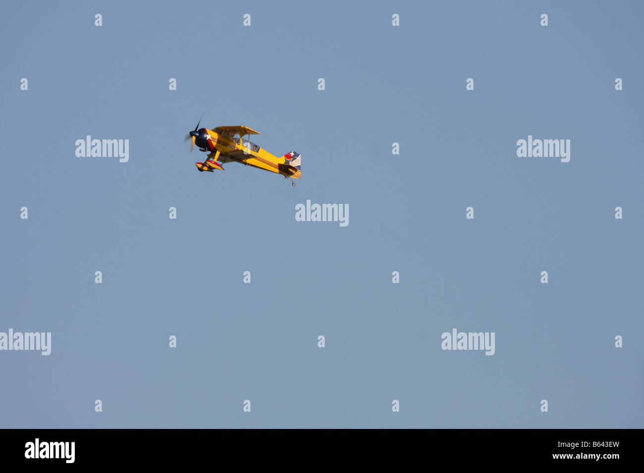 a yellow single engine plane flying in the air Stock Photo - Alamy