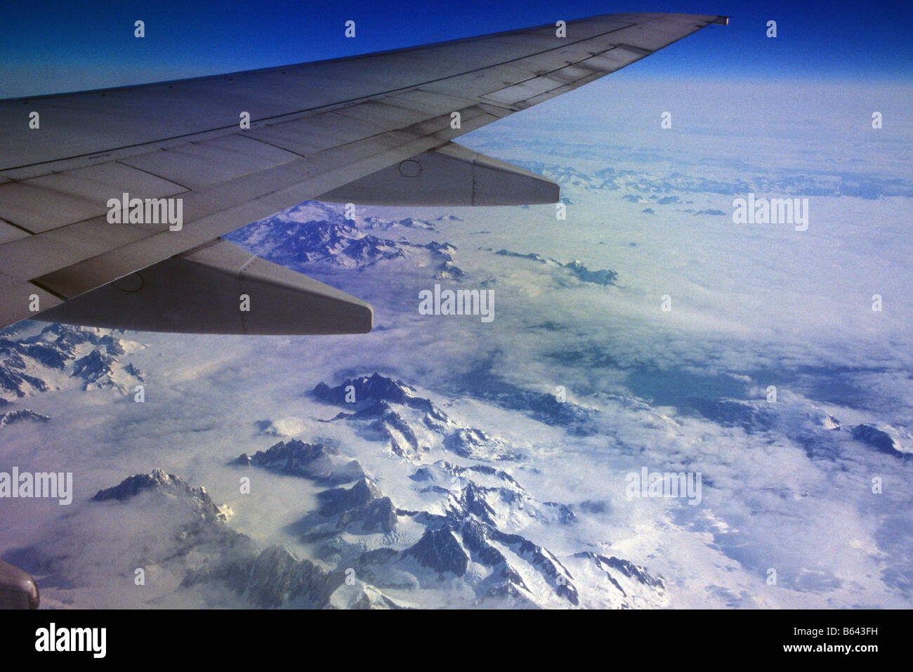 Wing of airplane above clouds and mountains of Alaska, USA Stock Photo ...