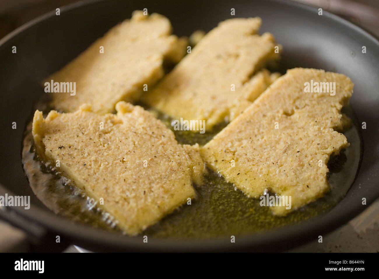 Frying wedges of Polenta the Italian version of cornmeal mush Stock ...