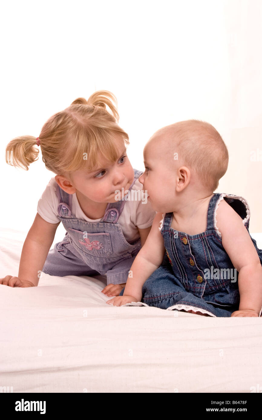 Two girl babieslooking at each other Stock Photo - Alamy