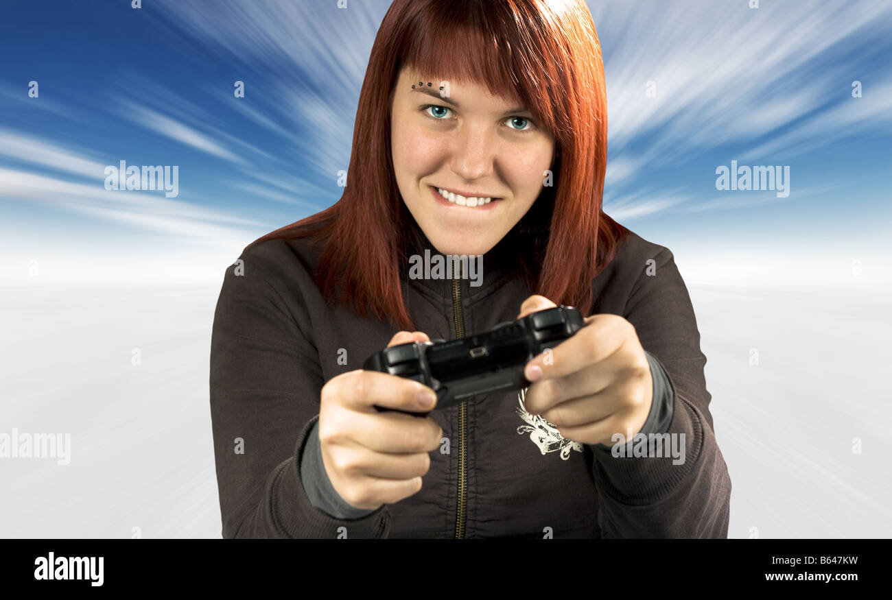 Photo of a happy beautiful redhead girl biting lips while playing video ...