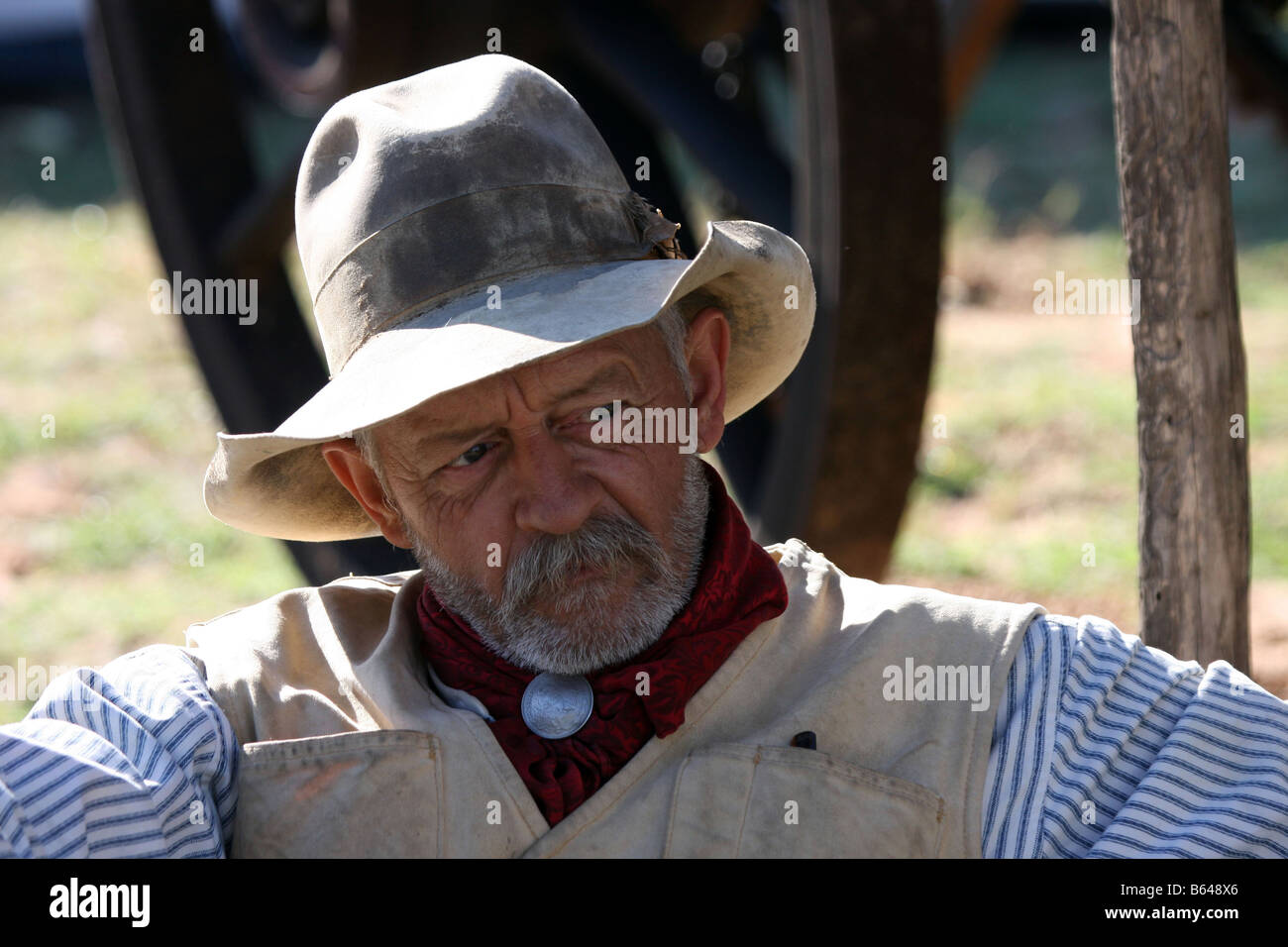 An old timer cowboy leaning against his pack and saddle next to the ...