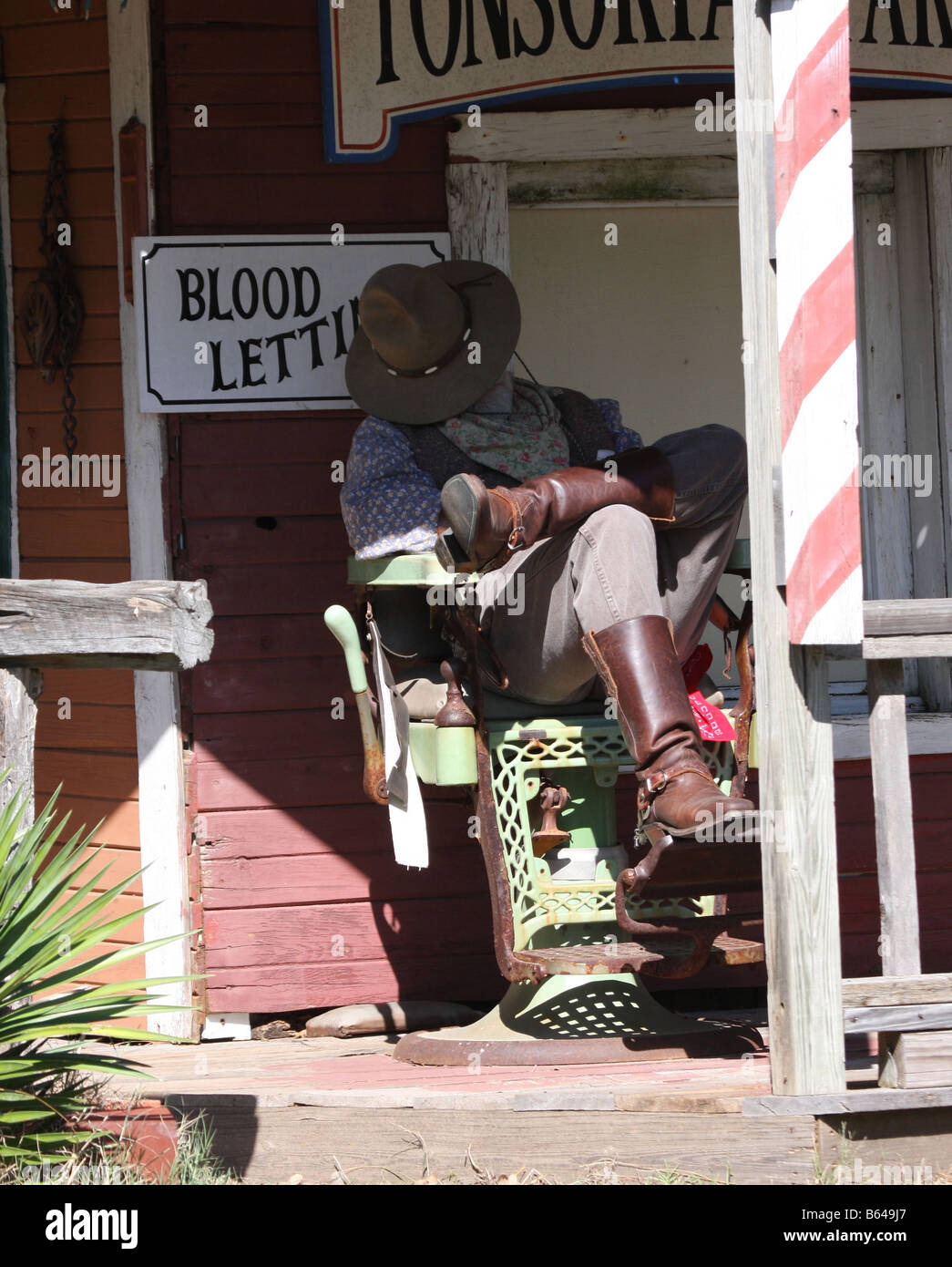 A cowboy taking a knap in front of the Barber shop with a sign about ...
