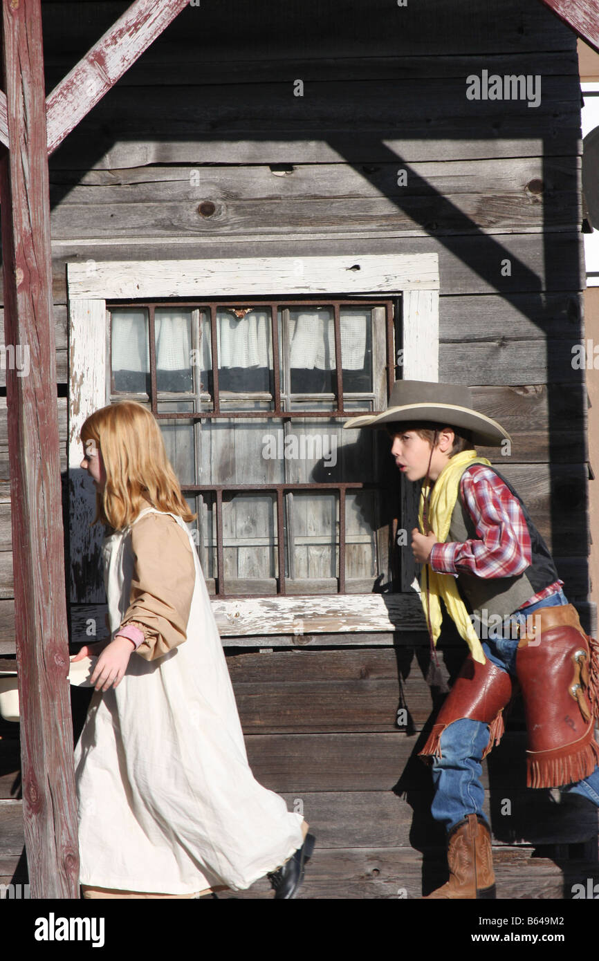 A boy and girl running in a chase in an old western town Stock Photo ...