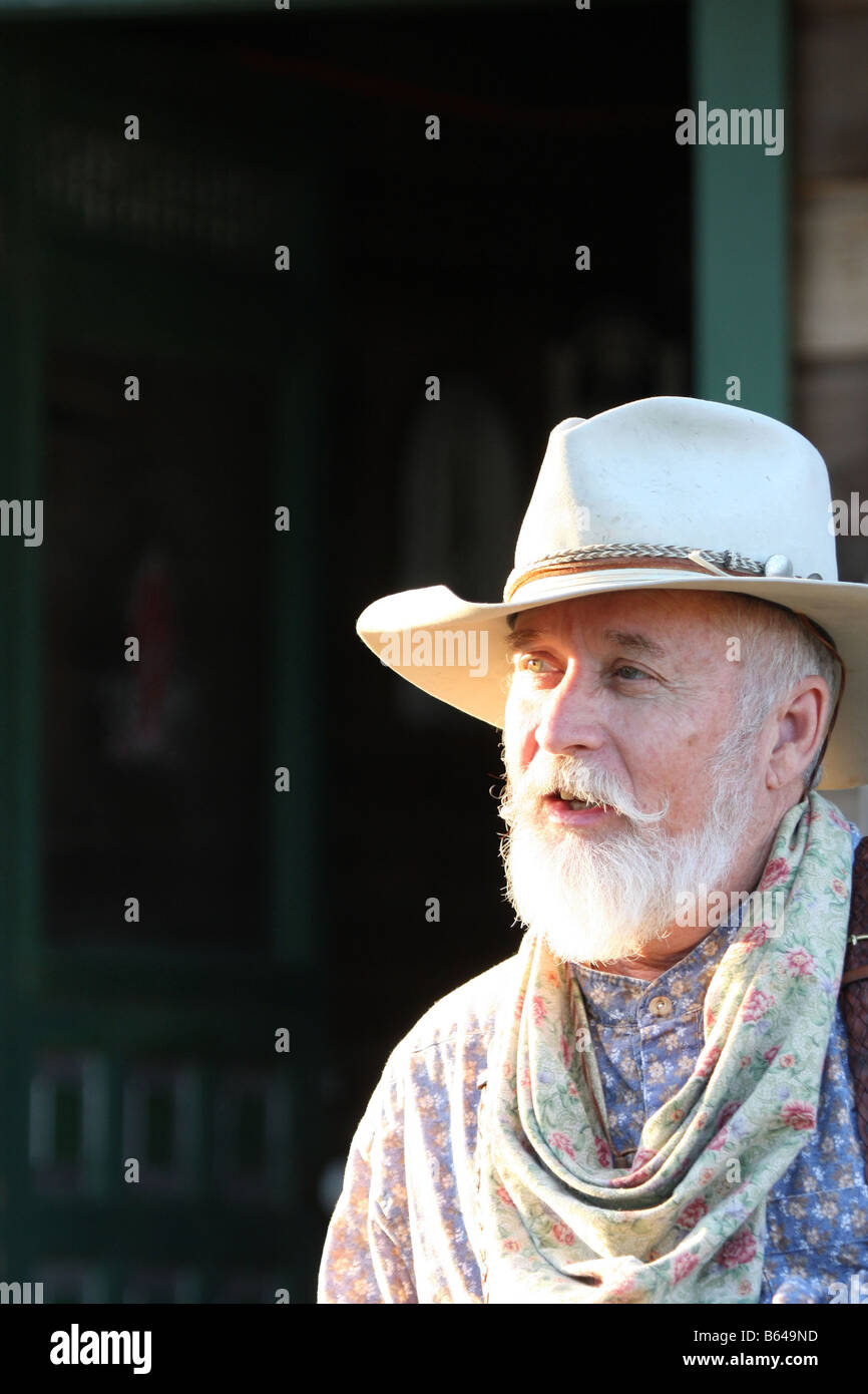 An old timer cowboy leaning against a horse tie rack Stock Photo - Alamy