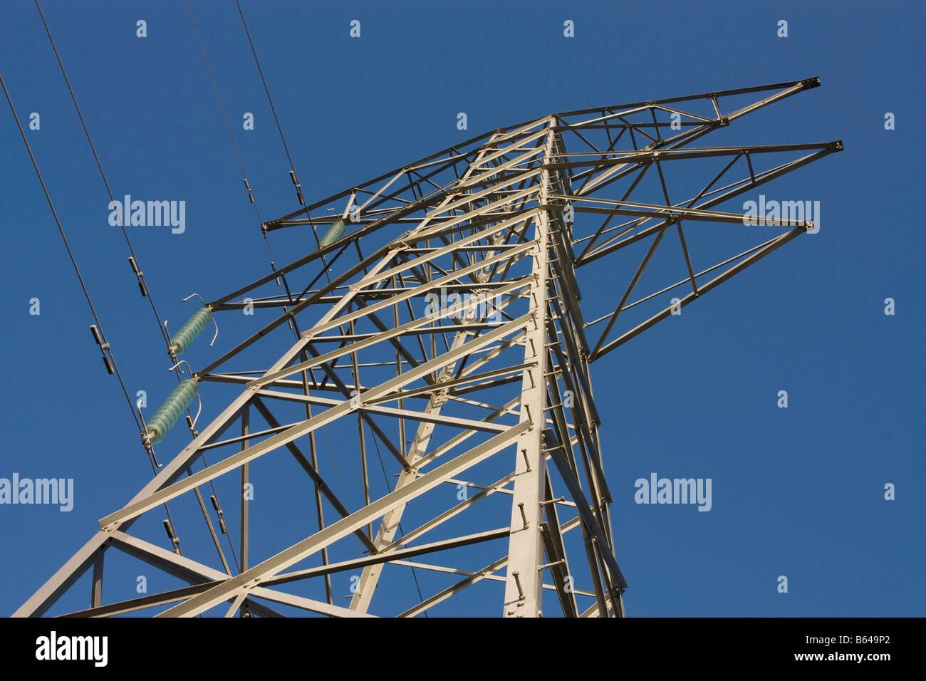 Electricity pylon against blue sky with barbed wire Stock Photo - Alamy