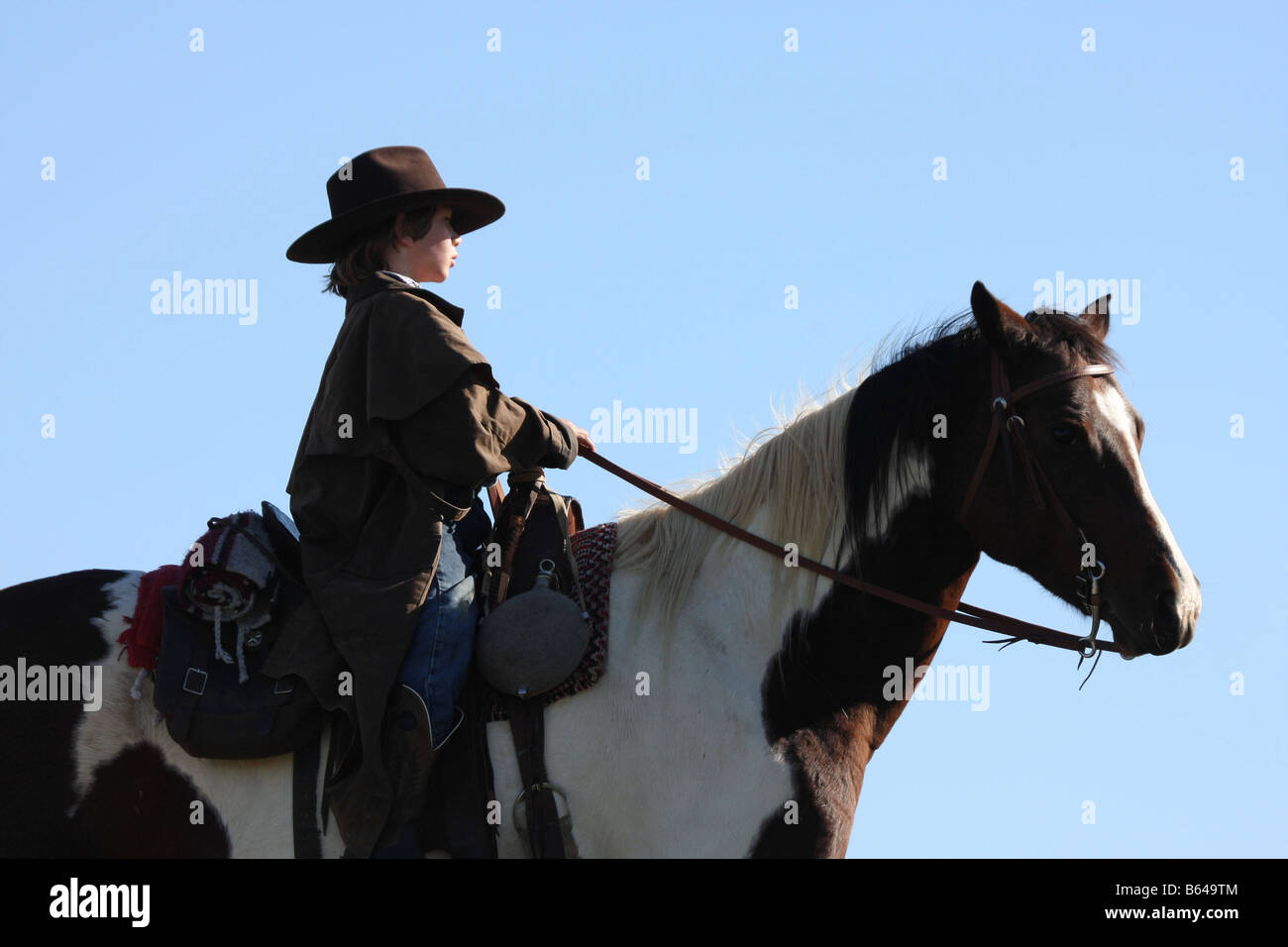 A young cowboy on horseback working the ranch Stock Photo - Alamy