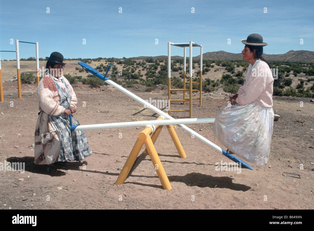 BOLIVIA - NATIVE AYMARA WOMEN PLAYING IN A SEE-SAW AT A VILLAGE IN THE ...
