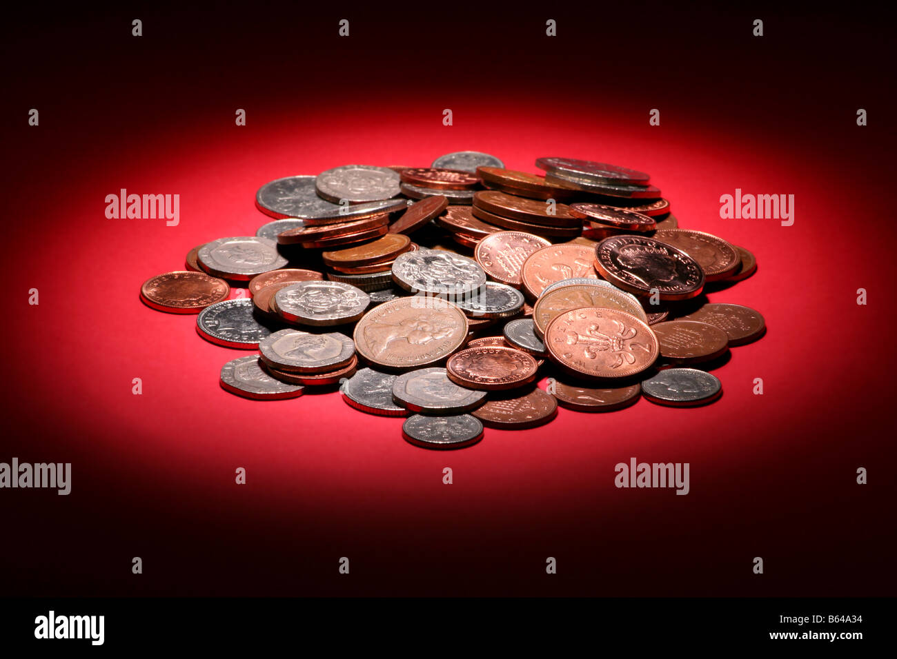 Pile of coins on red background Stock Photo - Alamy