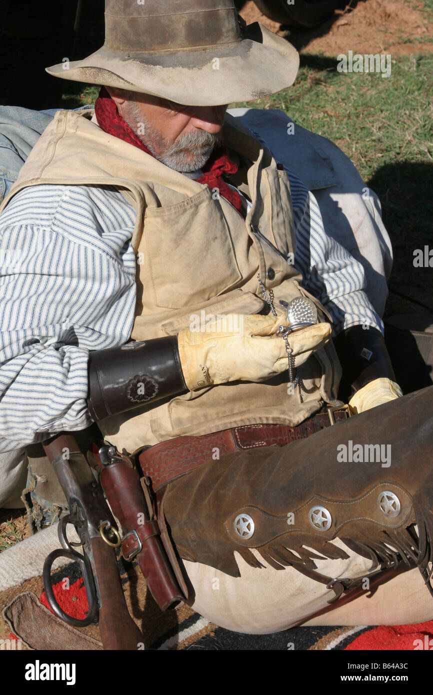 An old timer cowboy leaning against his pack and saddle next to the ...