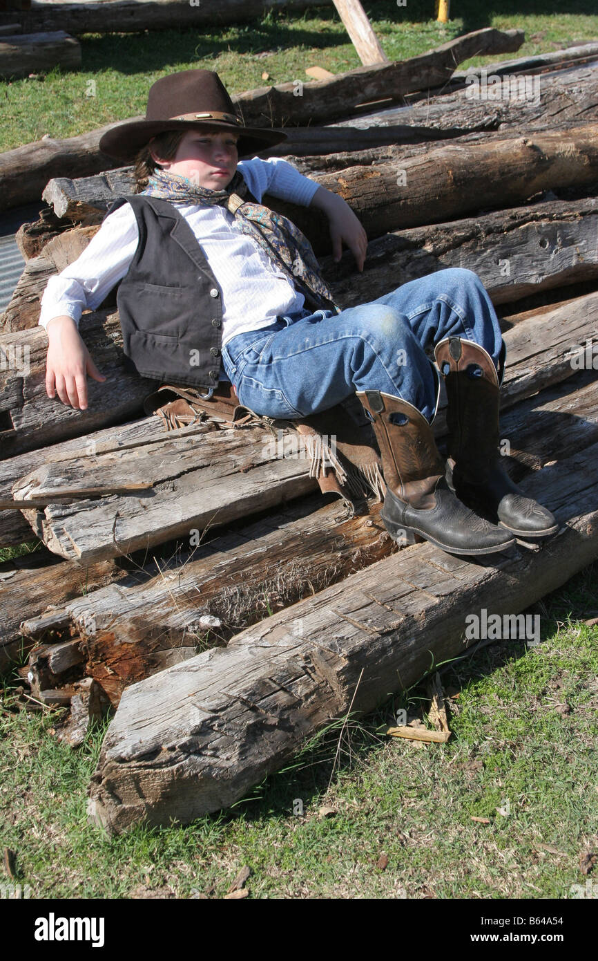 A young cowboy resting on a pile of wood Stock Photo - Alamy