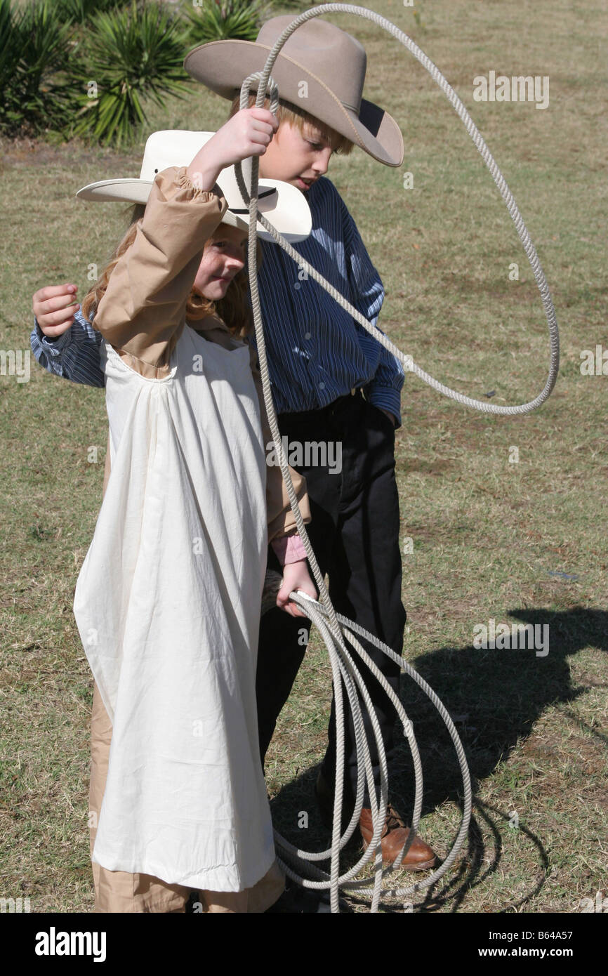 A young cowboy is teaching a young girl how to throw a rope Stock Photo ...