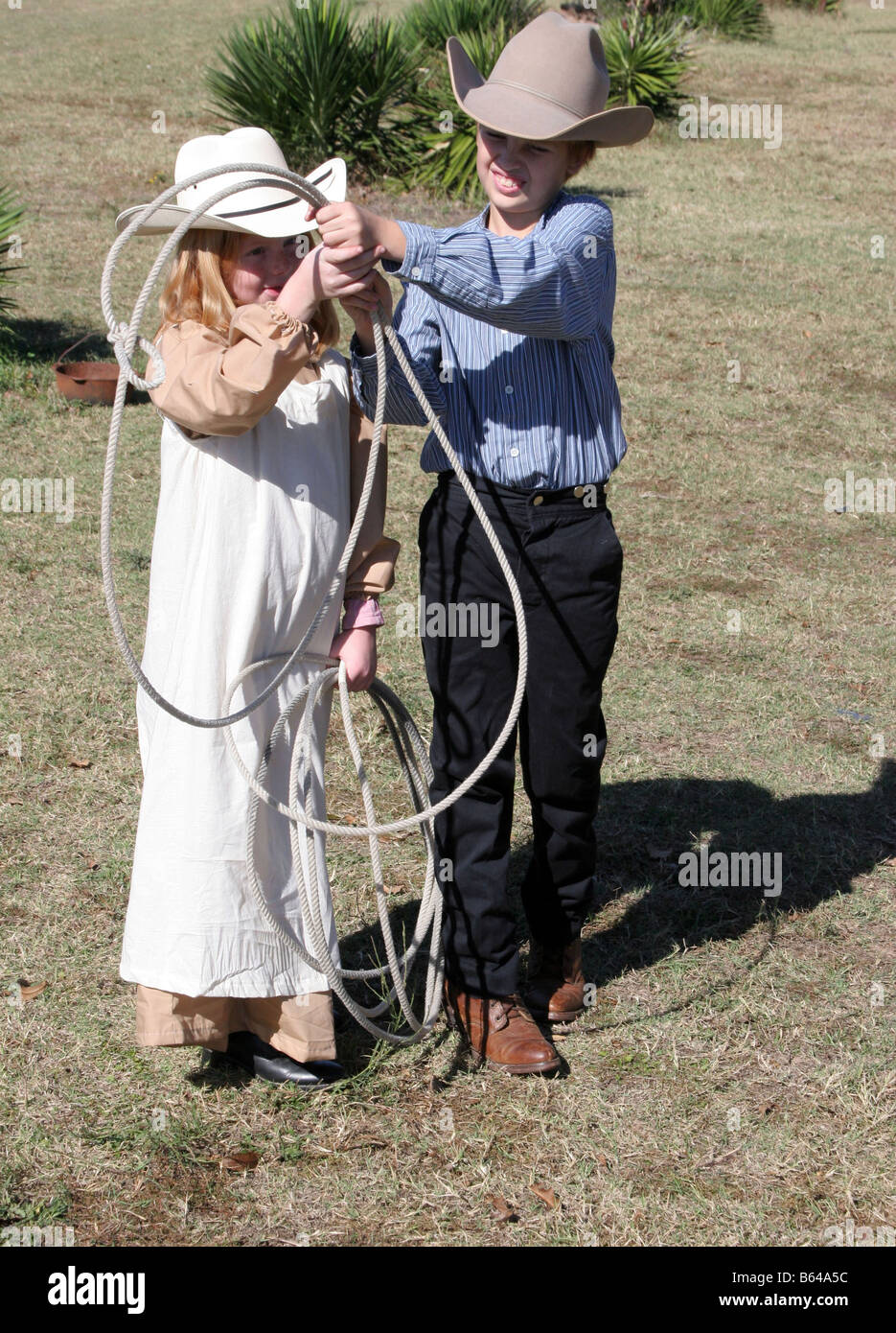 A young cowboy is teaching a young girl how to throw a rope Stock Photo ...