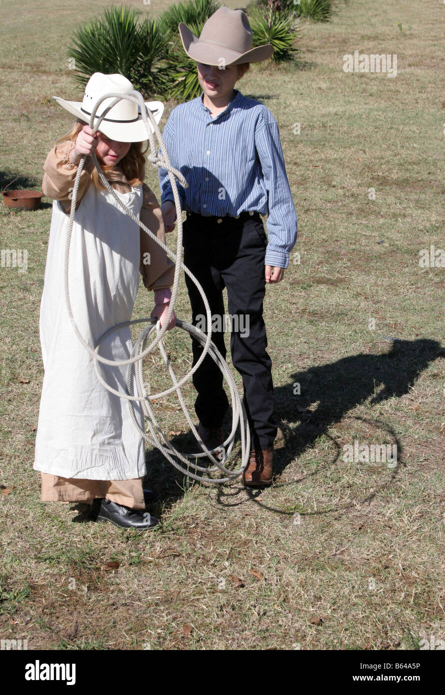 A young cowboy is teaching a young girl how to throw a rope Stock Photo ...