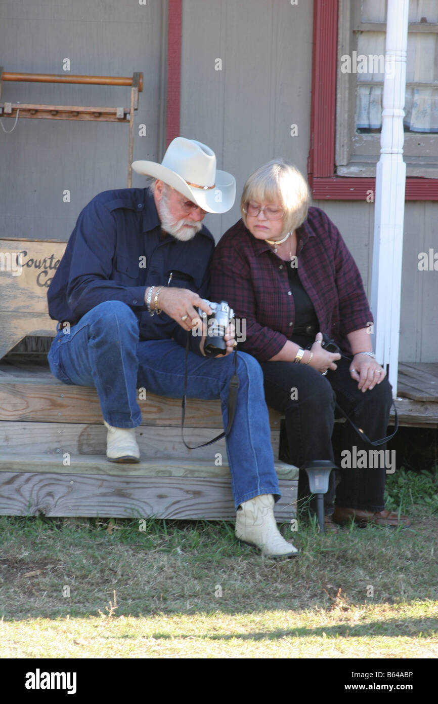 Two people viewing the photos on a digital camera at a photoshoot in a ...