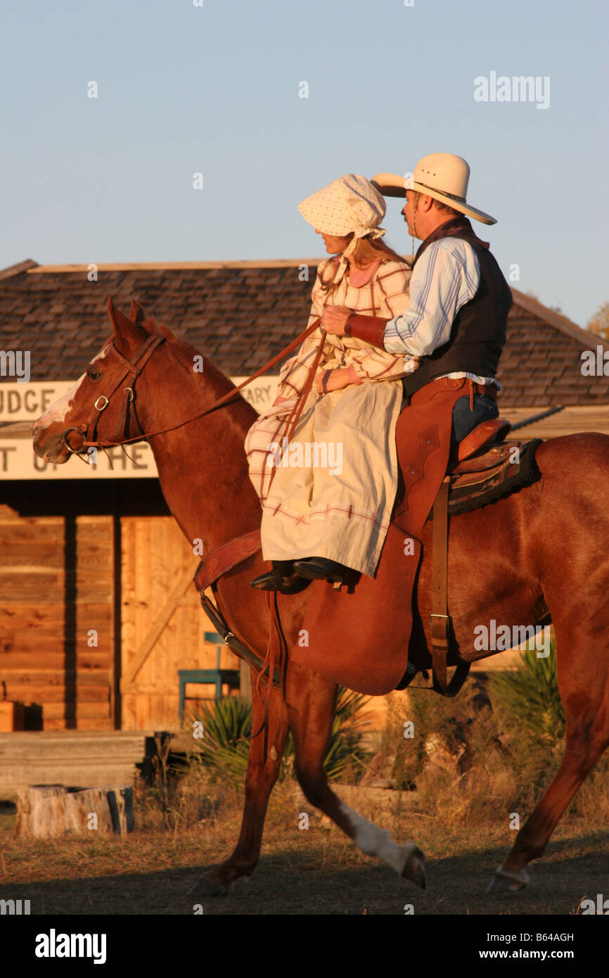 A young lady sharing a ride from a cowboy and his horse Stock Photo - Alamy