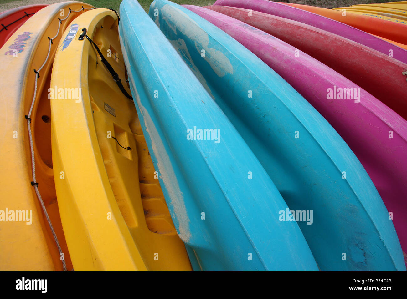 A ROW OF BRIGHTLY COLOURED CANOES ON A BEACH QUEENSLAND AUSTRALIA ...