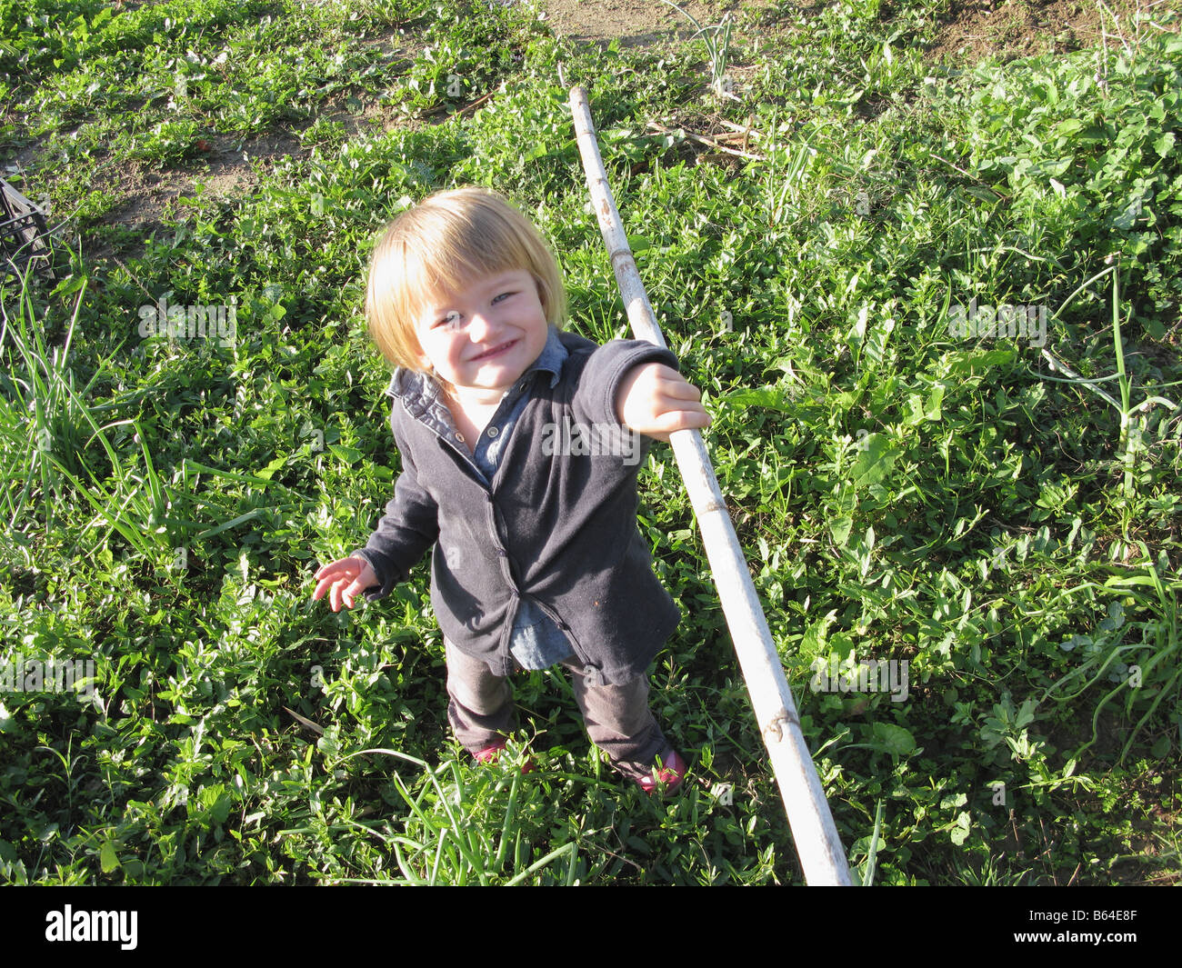 Child girl playing with stick Stock Photo - Alamy