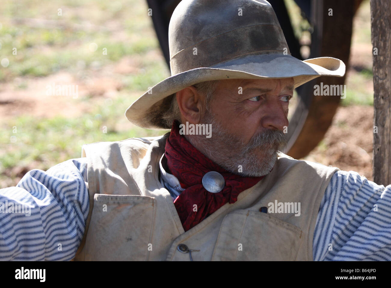An old timer cowboy leaning against his pack and saddle next to the ...