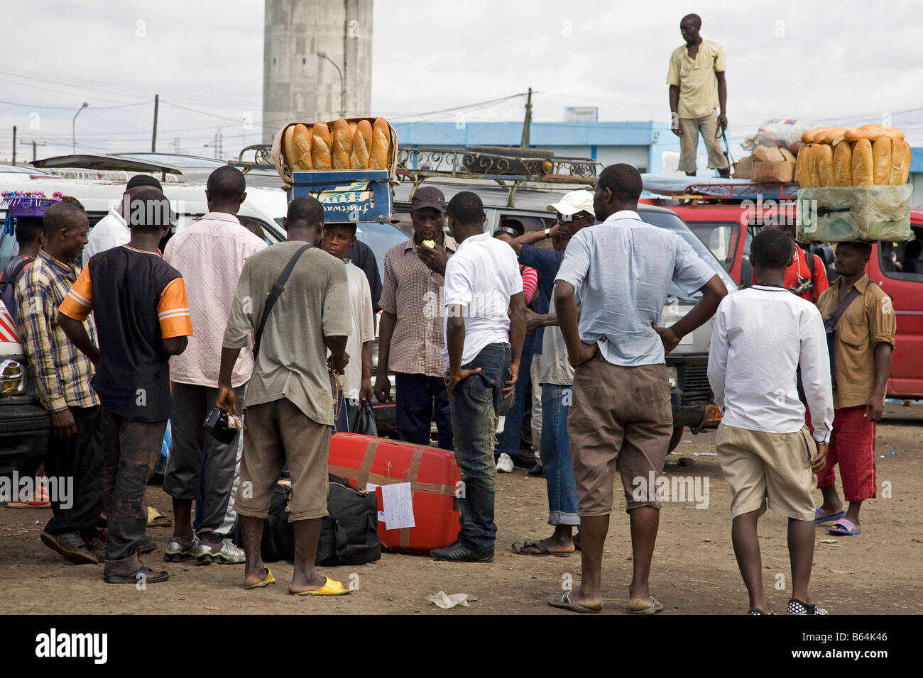 Passengers waiting in queue for minibus at terminus, Douala, Cameroon ...