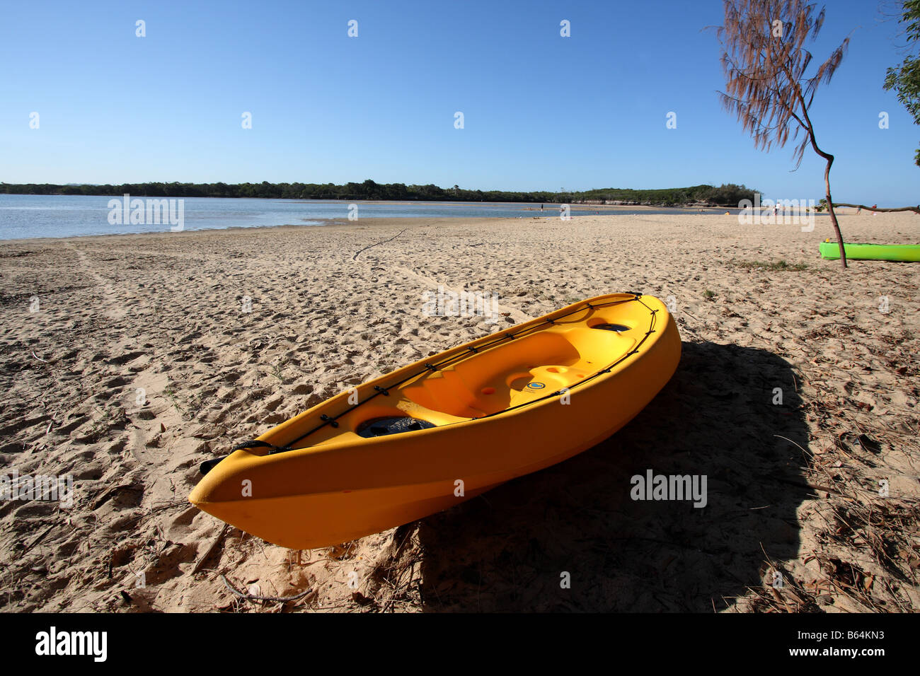 A BRIGHT GREEN CANOE ON SAND AT THE EDGE OF A LAKE HORIZONTAL BDA11157 ...