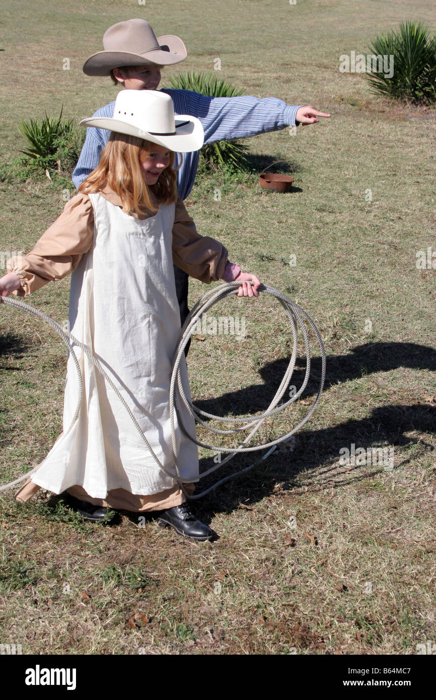 A young cowboy is teaching a young girl how to throw a rope Stock Photo ...