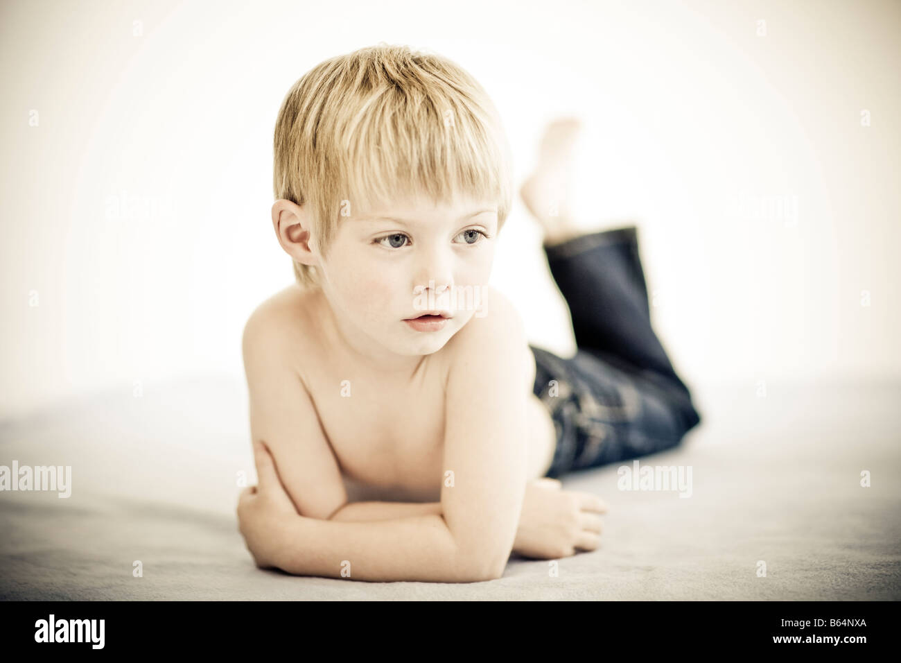 little boy laying on floor, propped on elbows Stock Photo - Alamy