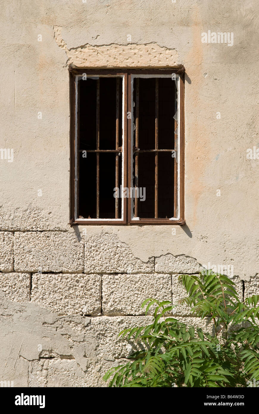 Broken window with bars of abandoned building, St. George's Bay ...