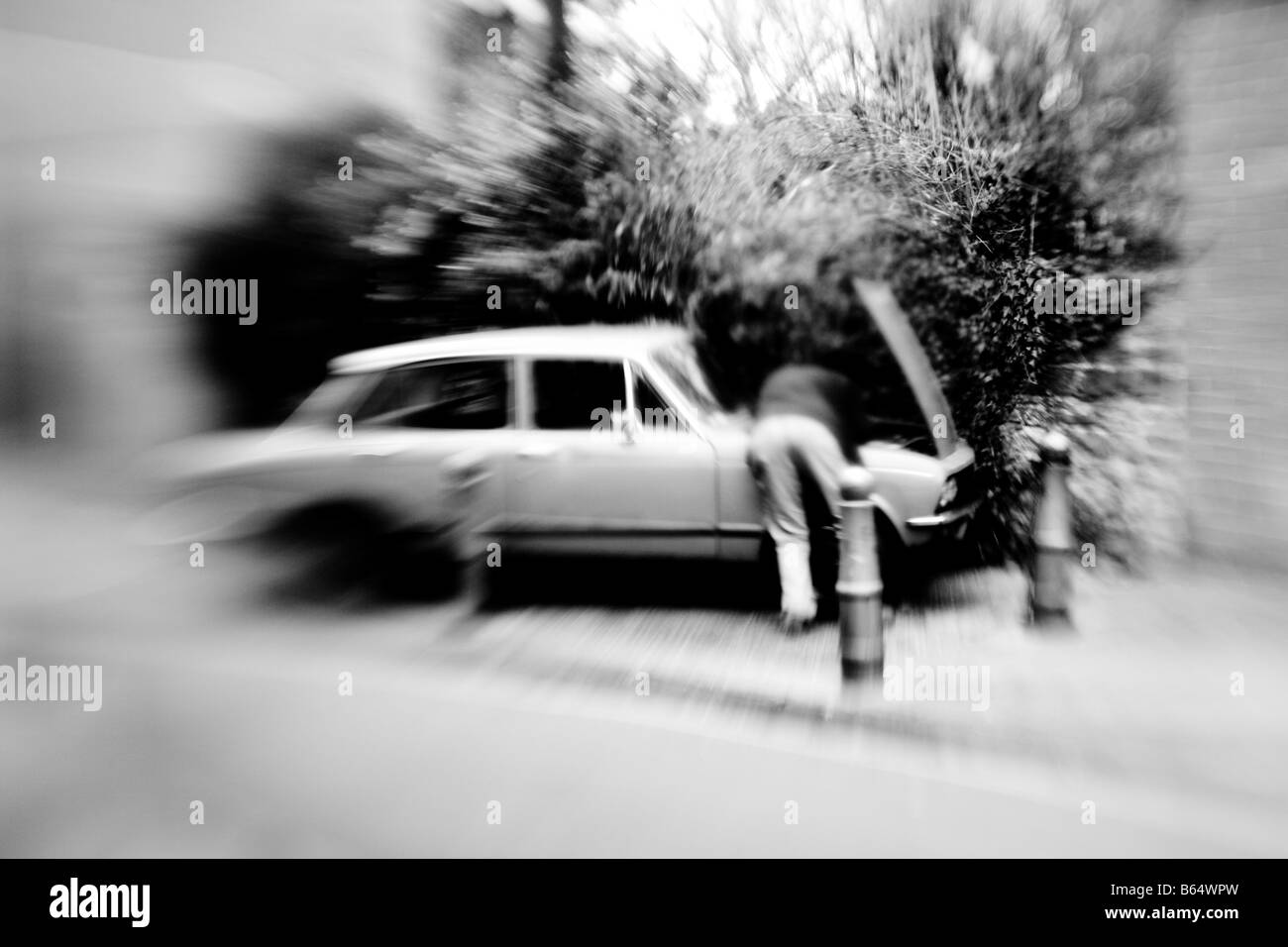 man leaning into engine bay of classic car Stock Photo - Alamy