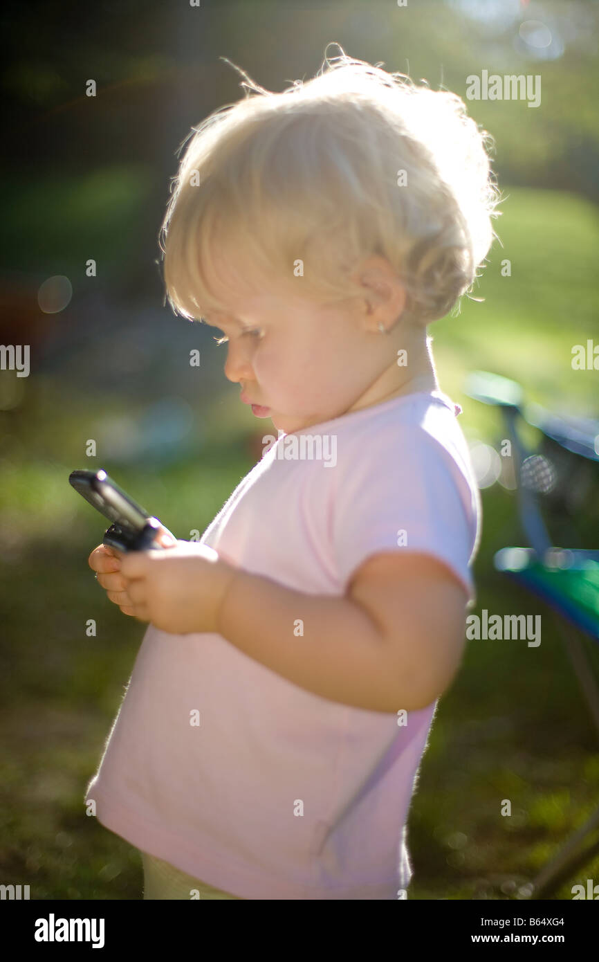 Baby girl playing with cell phone Stock Photo - Alamy