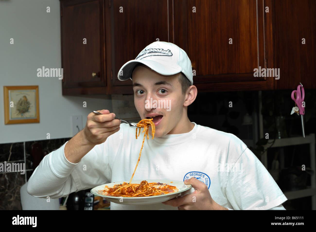 Teenage boy eating spaghetti Stock Photo - Alamy
