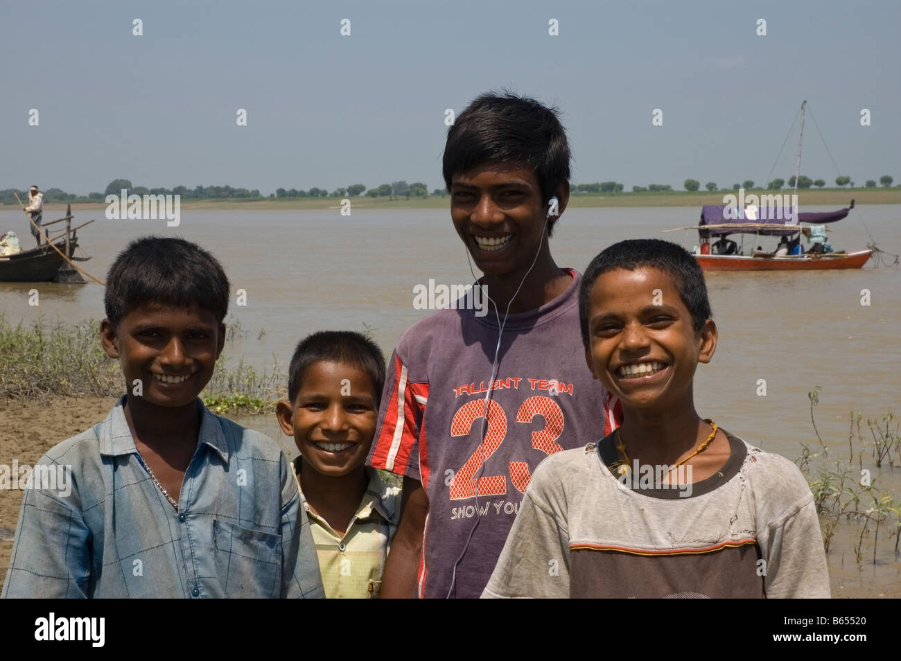 Four boys smile for the camera on the banks of the Ganges River in ...
