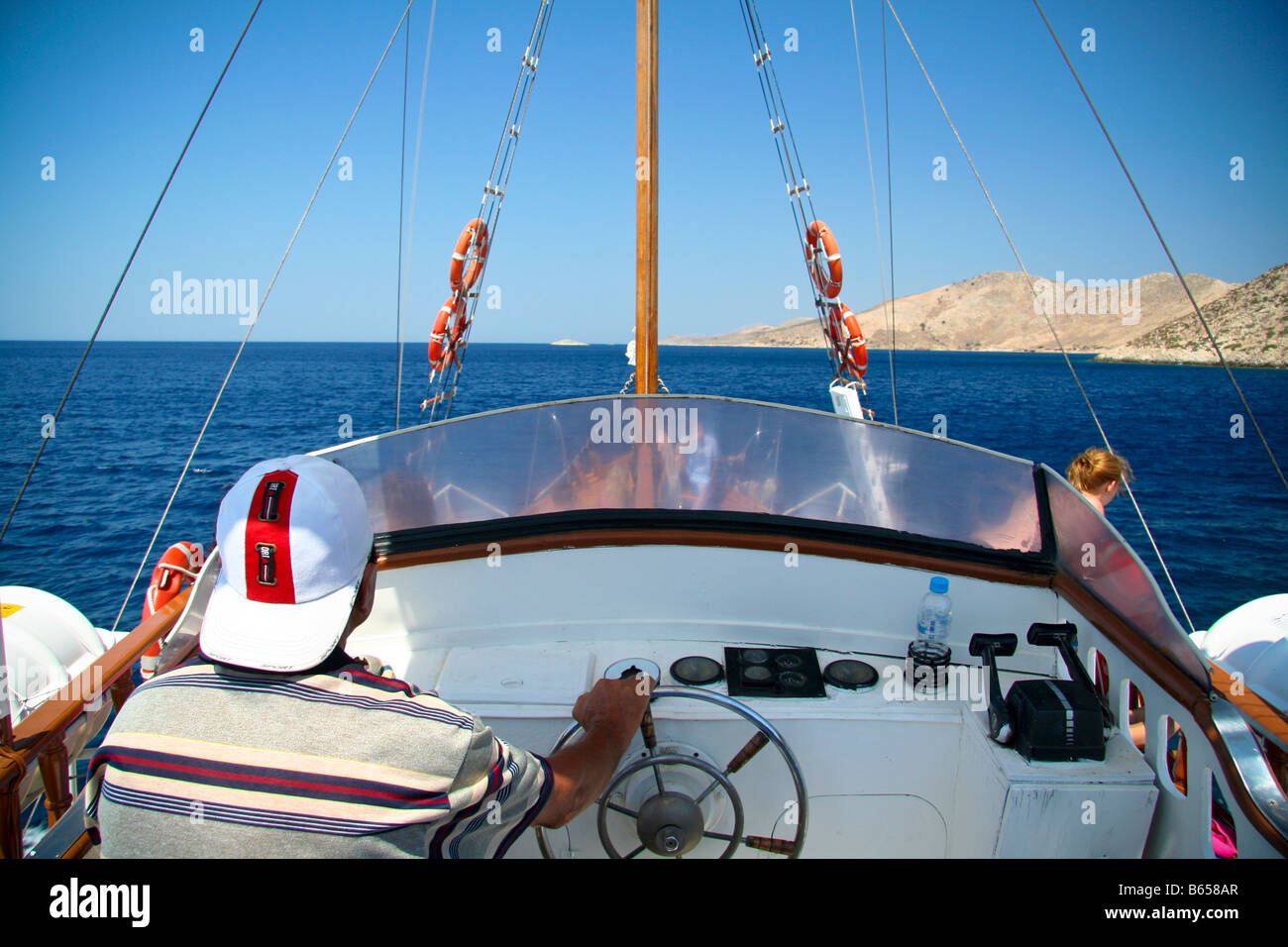 Captain steering his boat outside the Greek Island of Kos Stock Photo ...