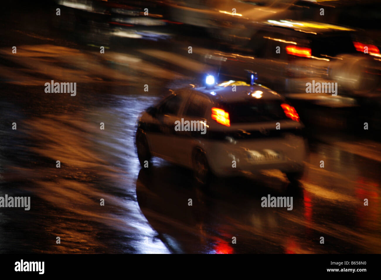 fast police car driving in heavy rain at night in town in italy Stock ...