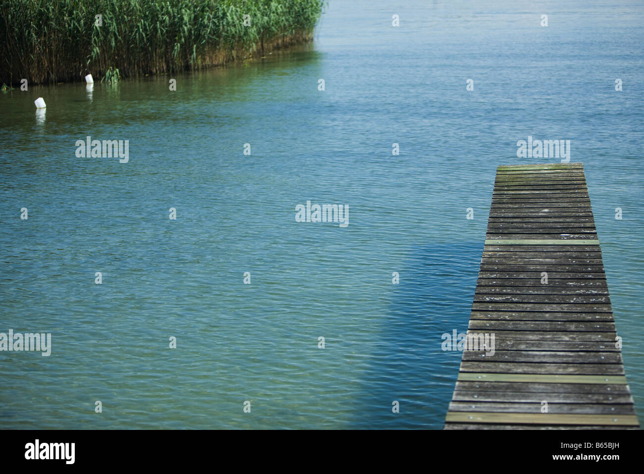 Pier over water, embankment in background Stock Photo - Alamy